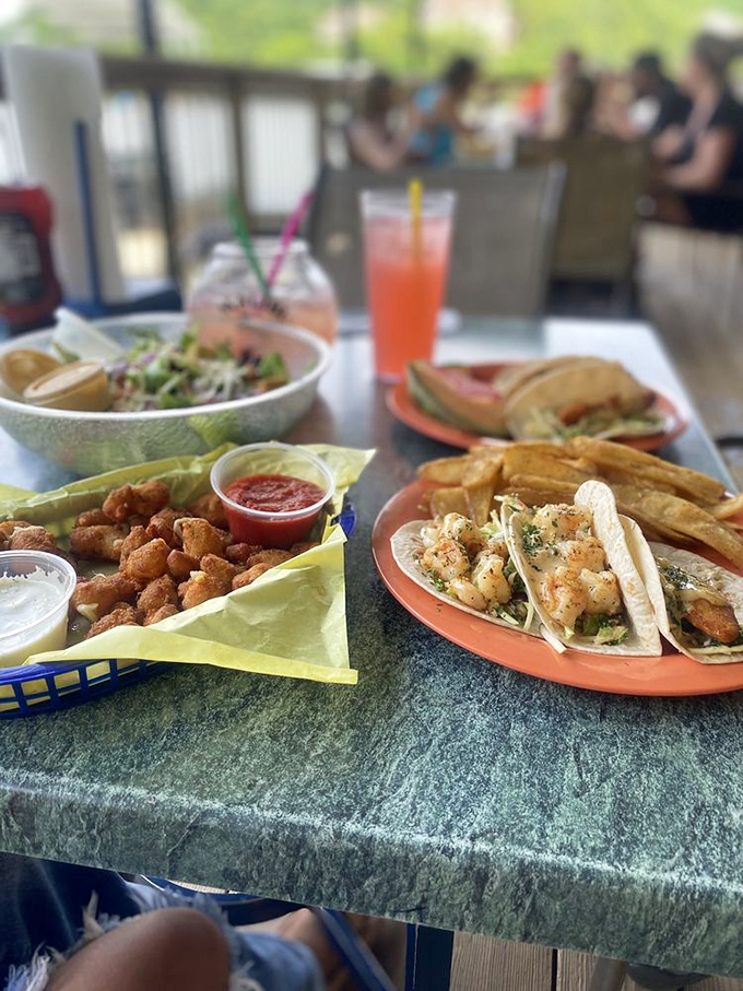 Shrimp tacos and gator bites sharing table space like the odd couple of seafood. The colorful spread is a lakeside fiesta on a plate.