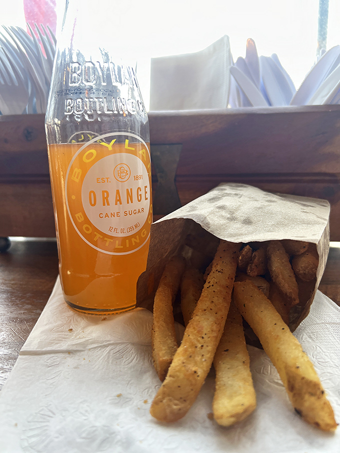 Golden fries nestled in paper alongside a bottle of orange soda&mdash;childhood nostalgia gets an artisanal upgrade.