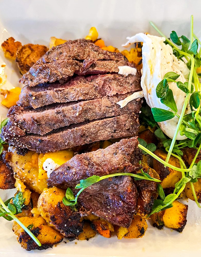 Carnivore poetry: perfectly seared steak slices resting on golden potatoes with fresh greens. Meat lovers, your moment has arrived.