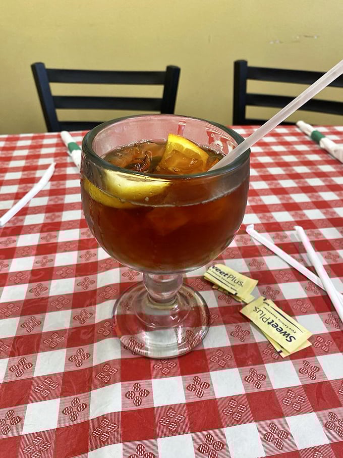 Sweet tea served in a goblet fit for royalty, because in Louisiana, proper hydration during a pasta feast is serious business.