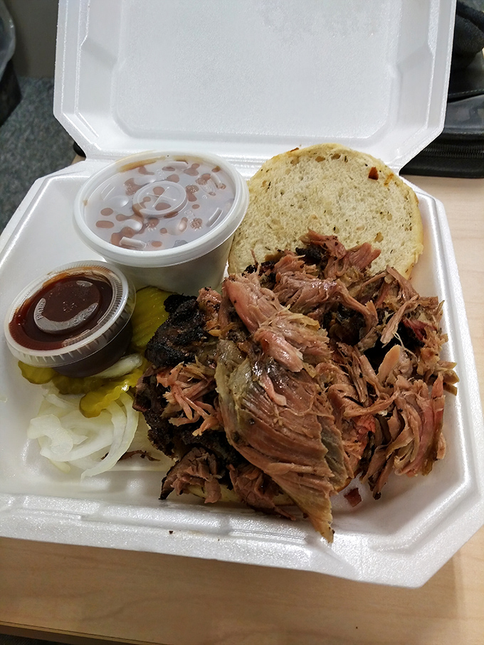 A pulled pork sandwich that demands two hands and zero distractions. The pickles and onions aren't garnish&mdash;they're essential supporting actors.