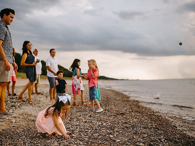Family memories being written in stone and sand. Generations gather at the shoreline, proving that the simplest pleasures&mdash;skipping rocks and collecting shells&mdash;remain timeless.
