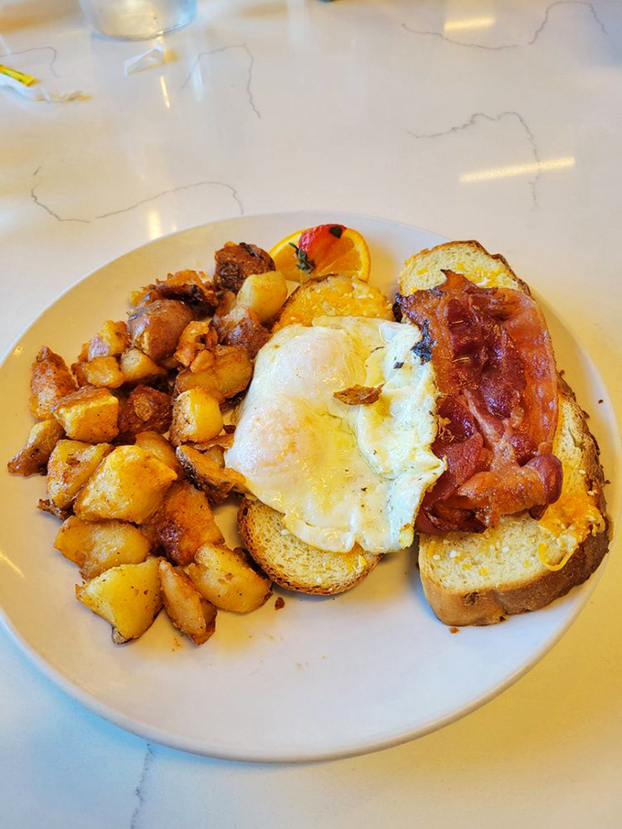 Morning sandwich diplomacy: bringing together crispy bacon, farm-fresh eggs and golden toast in perfect harmony on a pristine white plate.