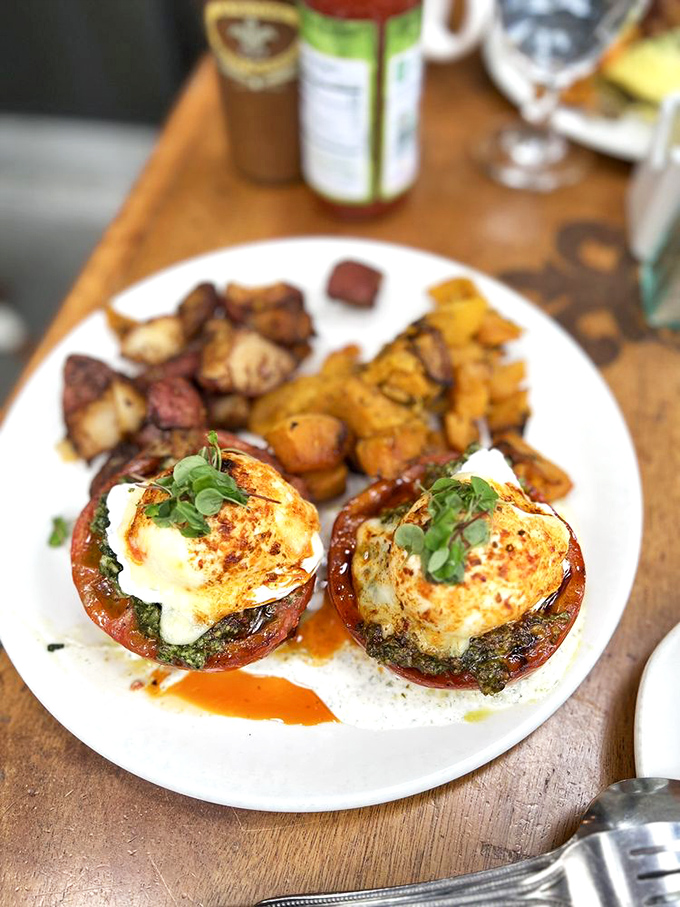 Breakfast perfection: roasted tomatoes cradle perfectly poached eggs, proving that simplicity executed flawlessly is the ultimate luxury. 