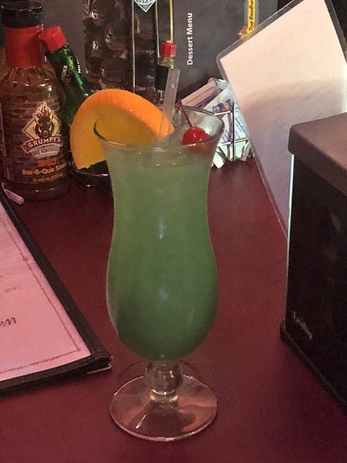 A vibrant green cocktail that says "vacation" even on a Tuesday. That orange slice and cherry? Not just garnish&mdash;they're a promise.