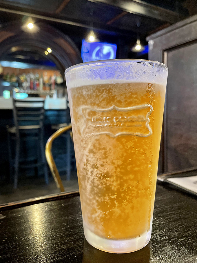 A perfectly poured pint catching the light just so &ndash; liquid amber with a foamy crown. Beer isn't just a beverage here; it's part of the architectural integrity of the meal.
