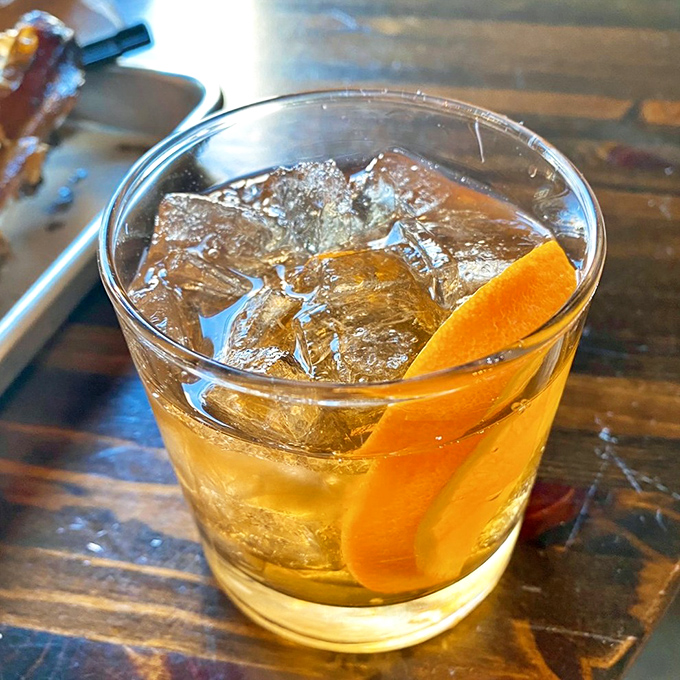An old fashioned with that perfect orange twist – because after conquering mountains of meat, you deserve a civilized moment of contemplation.
