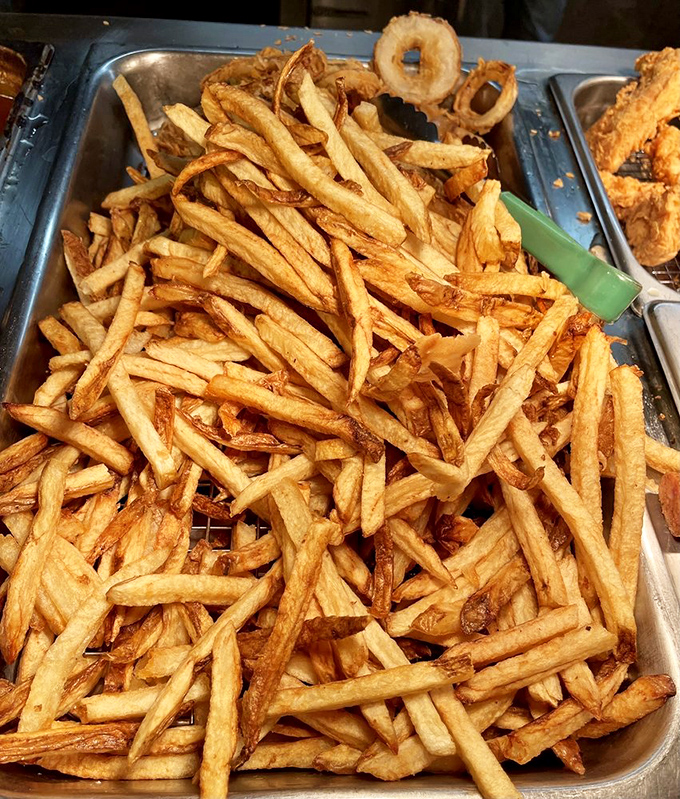 Hand-cut fries piled high like golden treasure &ndash; crispy on the outside, fluffy inside, and worth every extra minute on the treadmill tomorrow.
