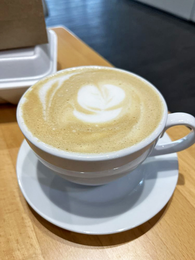 Coffee art that's almost too pretty to drink. Almost. This latte's heart pattern is sending love letters to your taste buds.