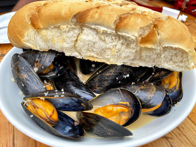 This mountain of mussels nestled in a crusty baguette isn't just a sandwich&mdash;it's a Neptune-approved flavor explosion waiting to happen.