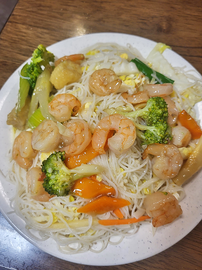 Delicate rice noodles cradle plump shrimp and vibrant vegetables in a sauce that manages to coat every strand without drowning it.