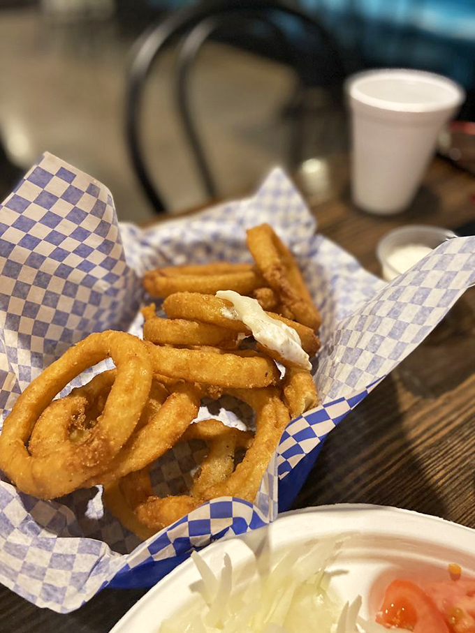 Golden onion rings stacked like delicious jewelry, crispy on the outside and tender within&mdash;proof that simple pleasures are often the best.