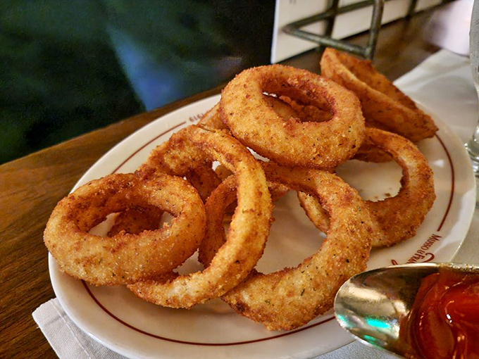 Golden onion rings stacked like delicious jewelry&mdash;crispy, seasoned halos that make fast food versions hide in shame.
