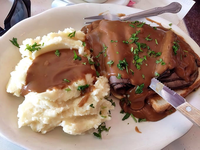 Roast beef so tender it practically surrenders, smothered in gravy and paired with cloud-like mashed potatoes that redefine comfort.