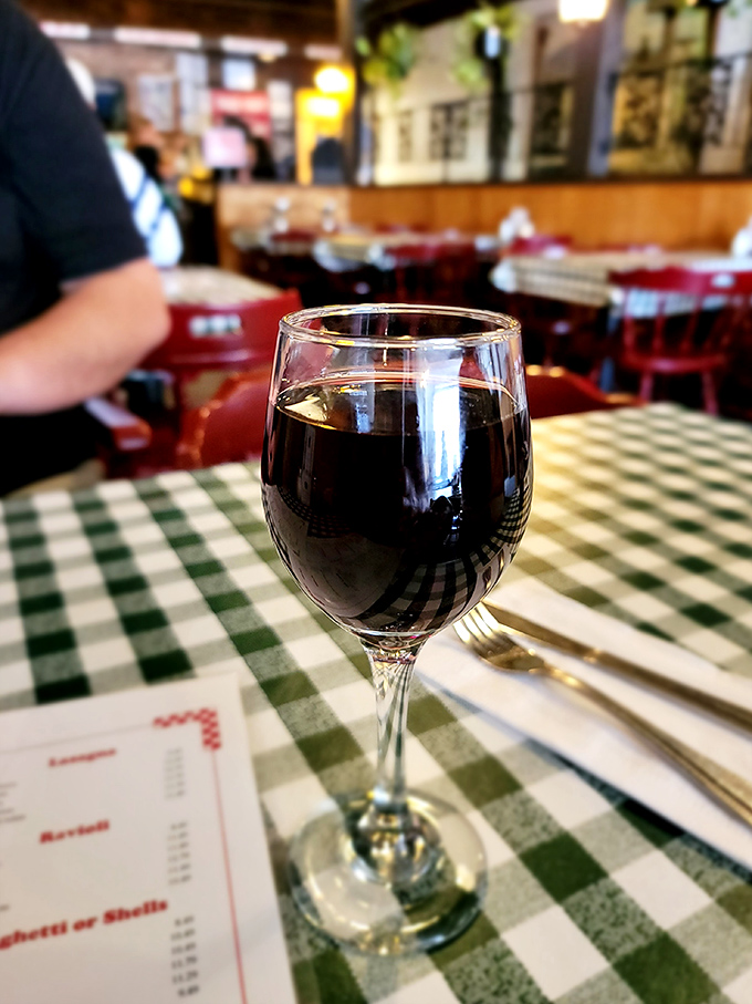 A glass of house red on a checkered tablecloth &ndash; sometimes the simplest pleasures are the ones that make you feel like you've finally figured life out.
