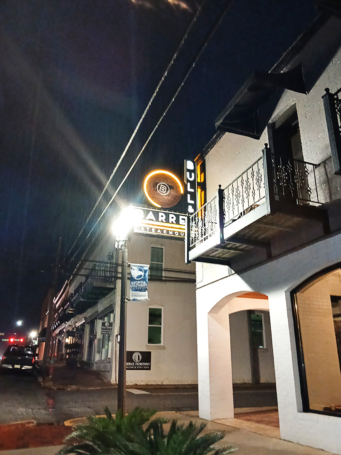 Bull & Barrel's illuminated sign glows like a lighthouse, guiding hungry souls through Statesboro's night to steak salvation.