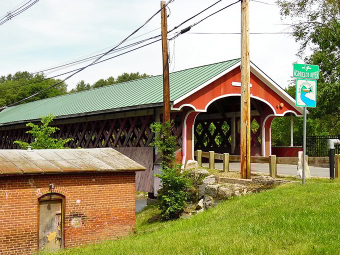 Swanzey's covered bridge stands as a crimson sentinel, guarding memories of horse-drawn carriages and simpler times.