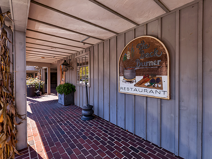 The Back Burner's weathered sign and rustic walkway promise comfort food elevated to an art form&mdash;steaks included.