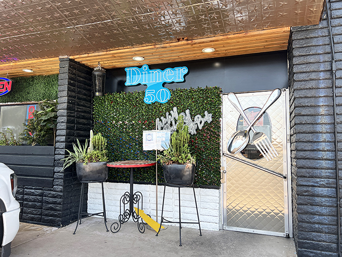 Greenery against black walls – the sophisticated entrance that says "Yes, diners can be chic AND serve perfect eggs."