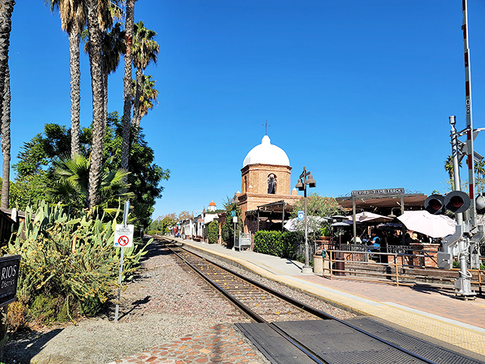 The train station serves as a community hub where commuters become friends and the rhythm of arriving trains marks the passage of small-town days.