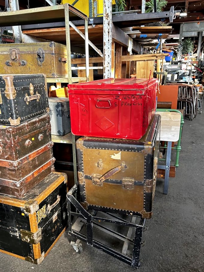 Steamer trunks and vintage suitcases stacked like a time-traveler's luggage claim. Each one could star in a Wes Anderson film.