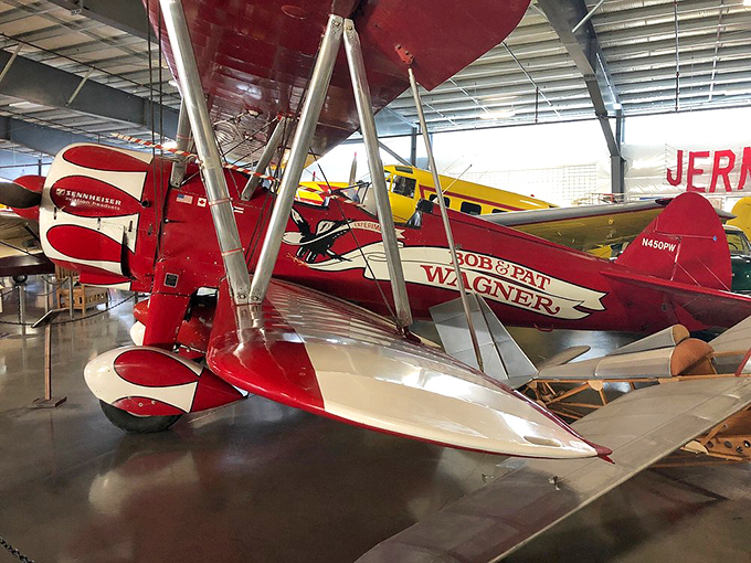The iconic PT-17 Kaydet biplane trained thousands of American pilots during WWII, its distinctive profile as recognizable as the flag it proudly wears.
