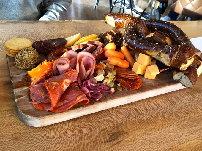 This charcuterie board featuring cured meats, cheeses, and a pretzel crown is like a United Nations of deliciousness on a wooden plank. 