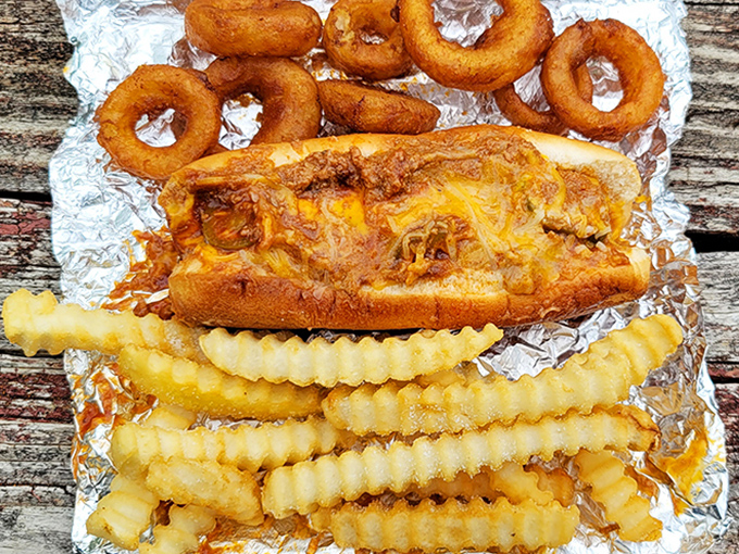 The holy trinity of comfort food: chili dog, crinkle fries, and onion rings. This aluminum foil platter is what childhood dreams are made of.