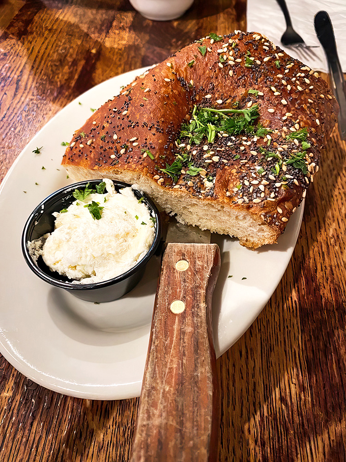 This isn't just bread—it's the opening act to a great meal. Crusty, seed-topped perfection with a side of creamy spread for good measure.