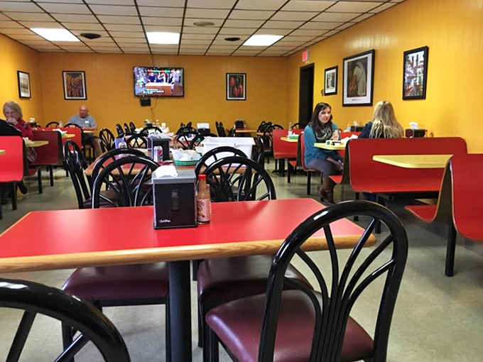 Red tables against yellow walls create a cheerful canvas for serious eating. This isn't just a dining room; it's where food memories are made.