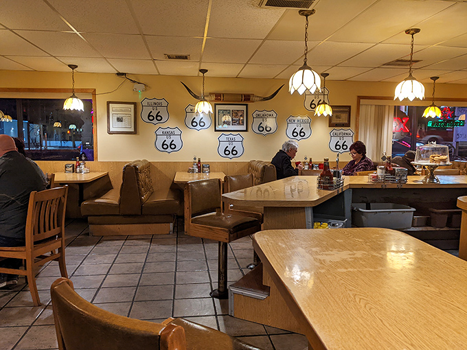 The Route 66 shrine wall watches over diners like guardian angels of the highway, blessing each booth with good food karma.