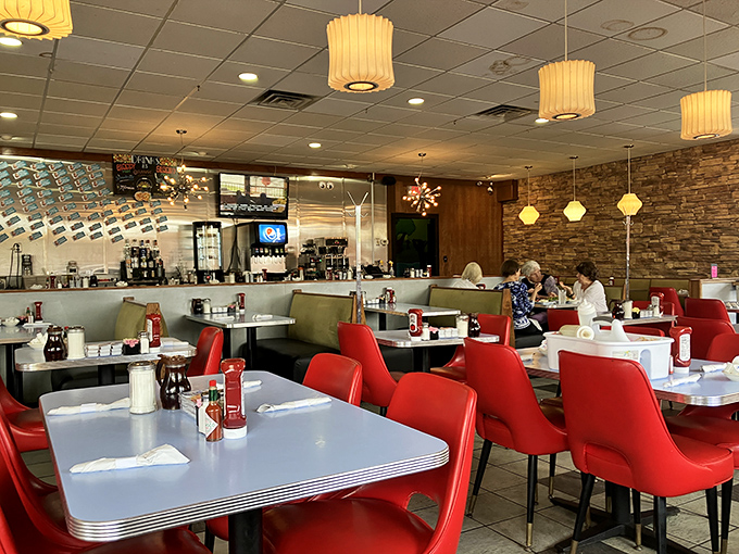 Red chairs and retro tables create the perfect stage for breakfast drama to unfold, complete with mid-century lighting for ambiance.