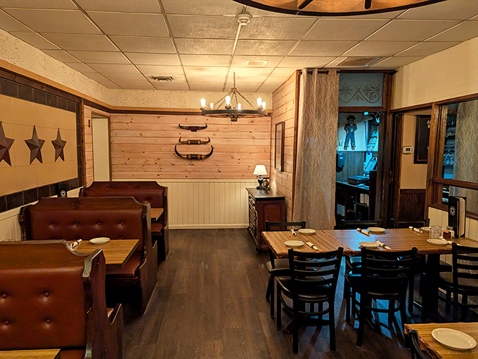 The dining room balances rustic charm with steakhouse sophistication. Those wooden dividers aren't just decorative&mdash;they're creating little kingdoms for carnivores. 