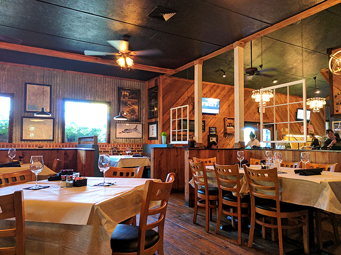 White tablecloths meet rustic wood paneling in this dining area where conversations flow as smoothly as the wine. Comfort marries elegance in perfect Southern style.