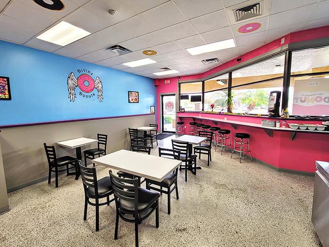 Simple white tables against vibrant walls create the perfect stage for the real stars of the show&mdash;the donuts that will soon occupy this space.