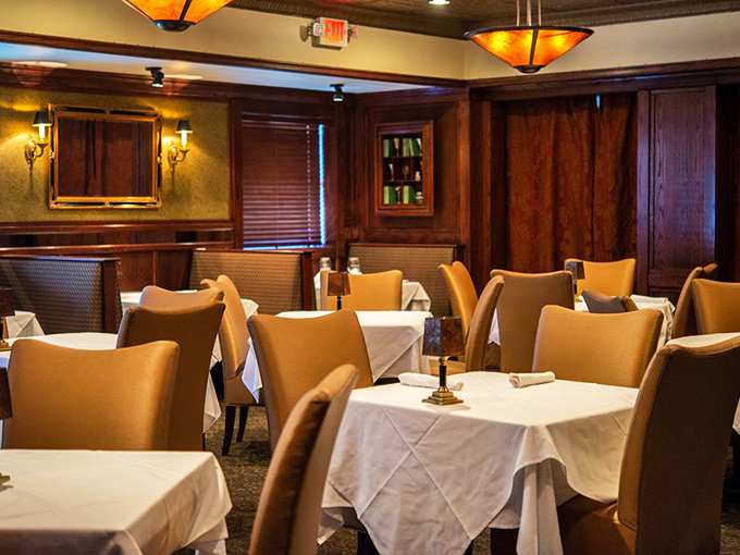 White tablecloths and cognac-colored chairs create dining spaces that feel both special occasion-worthy and surprisingly comfortable.