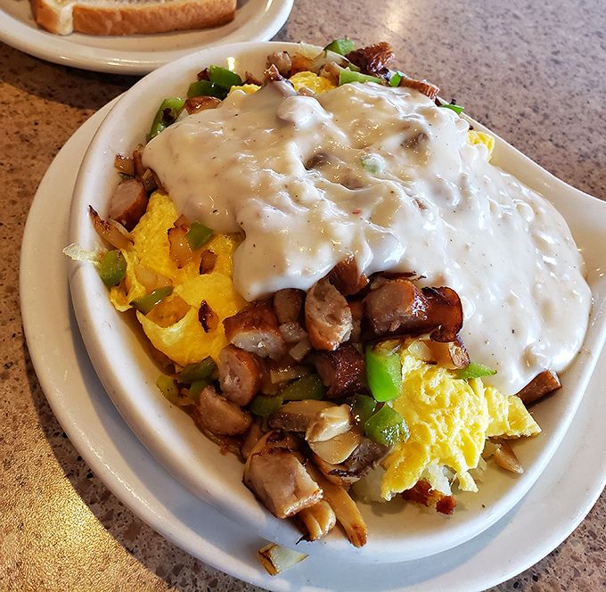 Breakfast skillet magic: eggs, meat, and vegetables performing a harmonious dance under a blanket of cheese. Hangover cure or celebration feast? Yes.