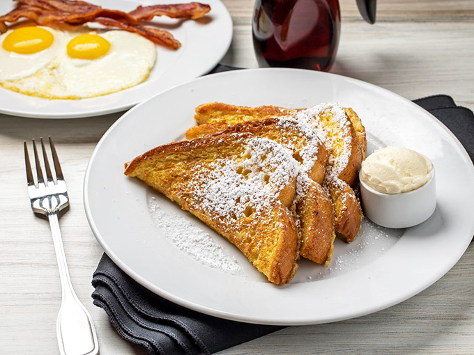 French toast that's achieved the impossible balance: crisp edges, custardy centers, and a dusting of powdered sugar that looks like morning snow.