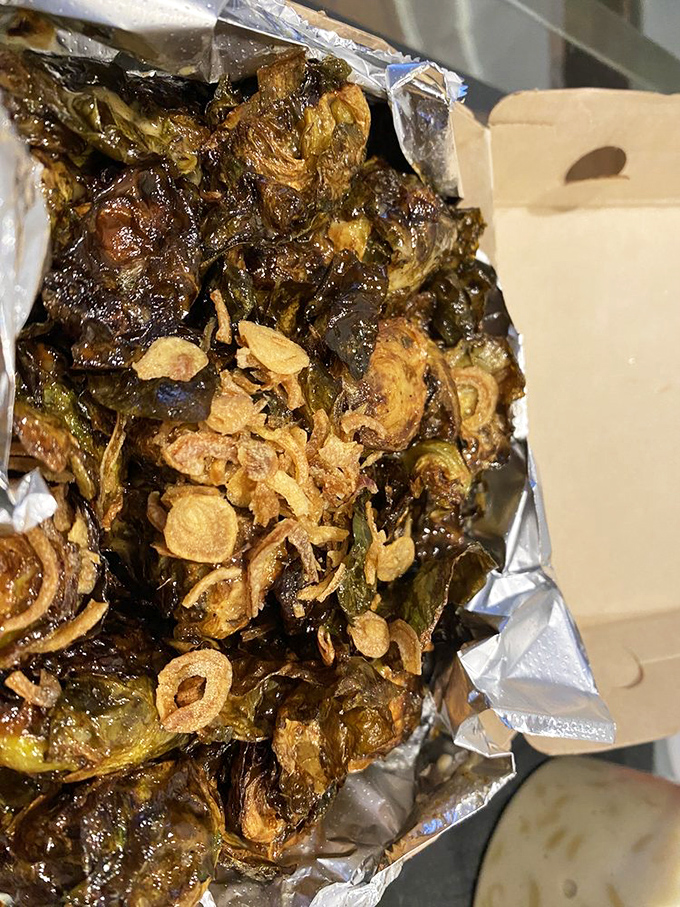 Brussels sprouts transcend their childhood reputation when fried crispy and topped with what appears to be crispy shallots &ndash; vegetable redemption at its finest.