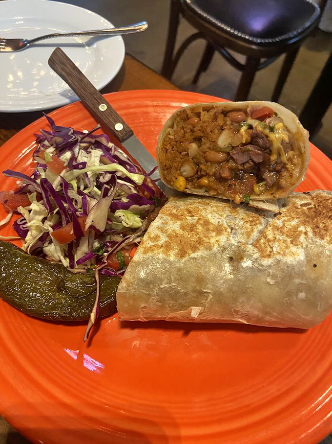 This burrito has been sliced open like a scientific specimen, revealing the perfect ecosystem of beans, cheese, and spice within.