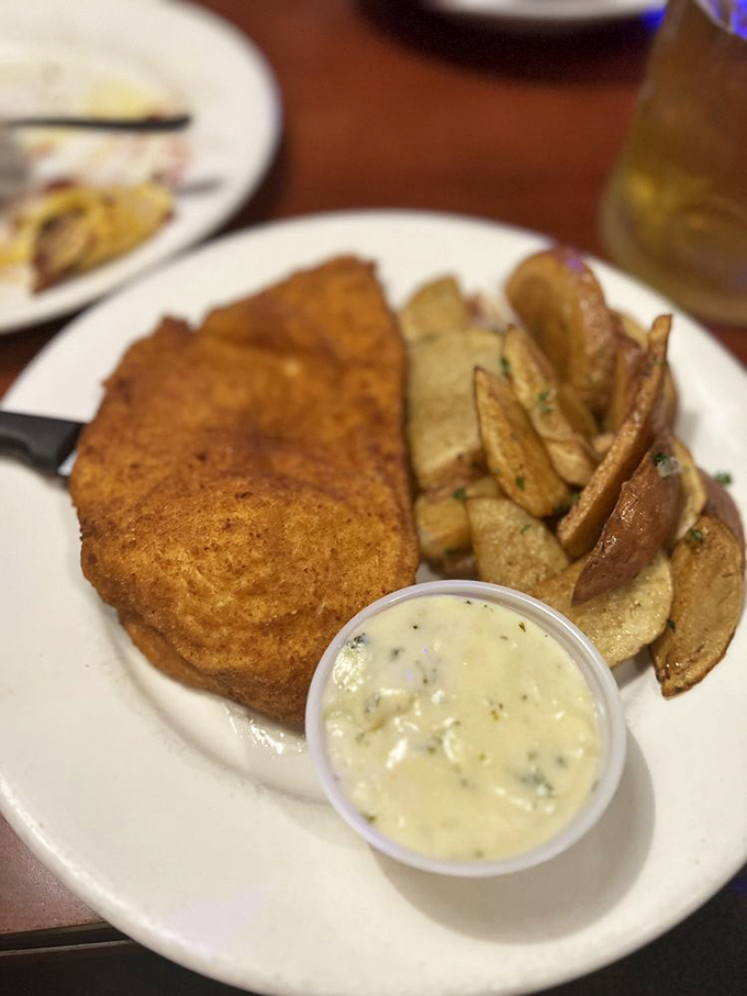 This H&uuml;hnerschnitzel doesn't just hang over the edge of the plate&mdash;it establishes dominance over it, while that creamy sauce whispers, "Resistance is futile."