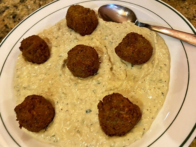 Golden-brown falafel islands in a sea of creamy hummus. If comfort food had a Mediterranean passport, this would be its photo.