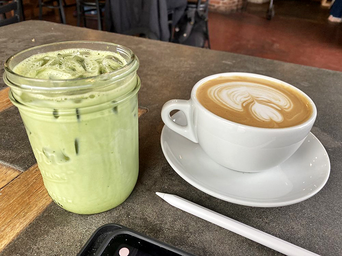 The vibrant matcha creation looks like it contains all the antioxidants you skipped last week, sitting beside coffee like the health-conscious cousin at Thanksgiving.