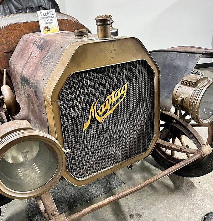 The weathered Maytag radiator grille tells stories of dusty country roads and Sunday drives that were once the highlight of the week.
