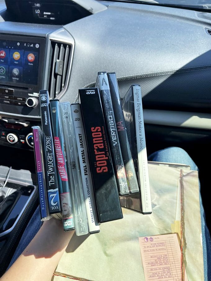 A stack of cinematic treasures ready for the ride home. The receipt suggests someone has excellent taste in both books and music.