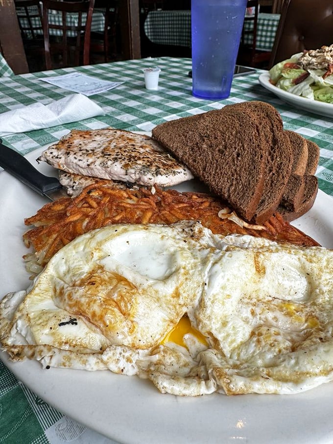 Toast so perfectly golden it belongs in a museum, alongside eggs that define what "sunny-side up" should always aspire to be.