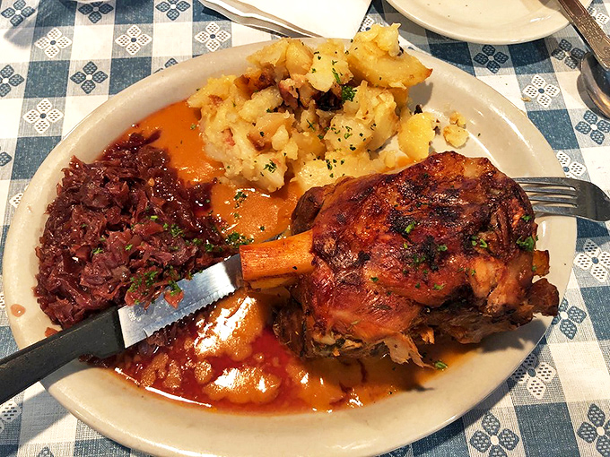 The pork knuckle arrives like a medieval feast&mdash;crispy skin, tender meat, and red cabbage that thinks tangy thoughts while you devour everything.