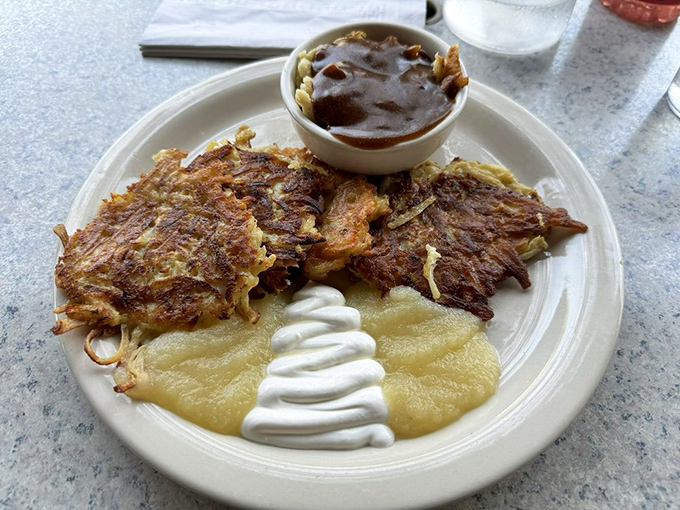 Crispy potato pancakes meet applesauce in a dance as old as time. That little cup of sauce is plotting to make your taste buds throw a spontaneous polka party.