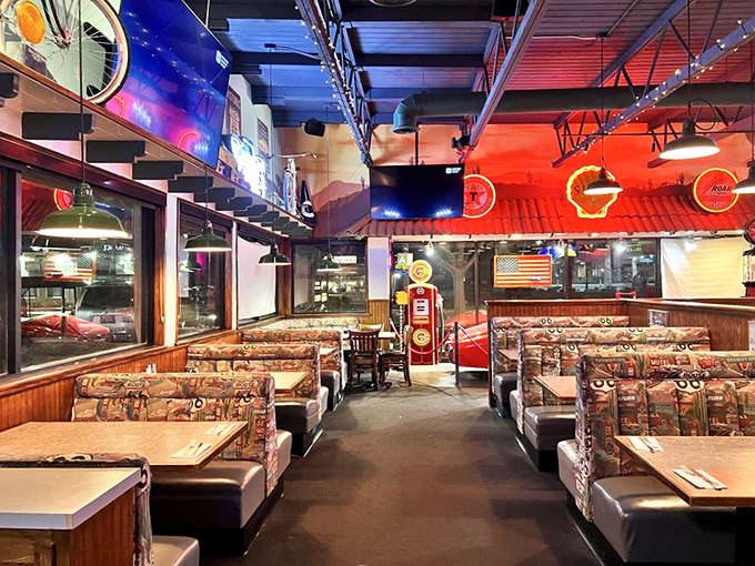 Neon signs cast that perfect rosy glow across booth seating straight from 1955. Even the light fixtures are working overtime on your nostalgia.