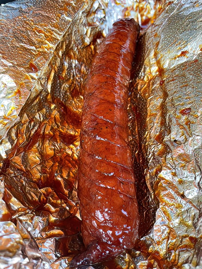 That sausage link isn't just food; it's a smoky, spicy work of art wrapped in a glistening, caramelized jacket.
